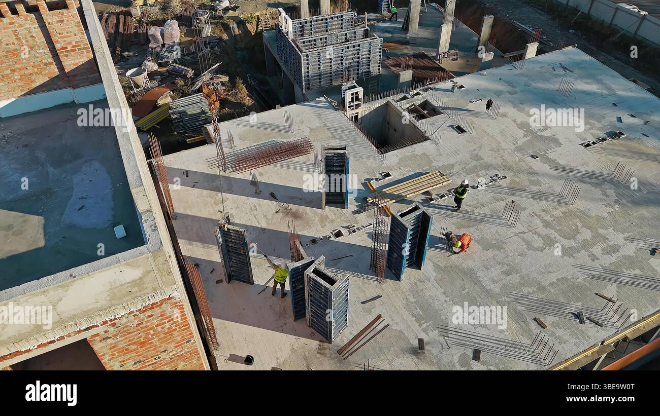 Aerial view of a construction site, workers assembling formwork on a ...