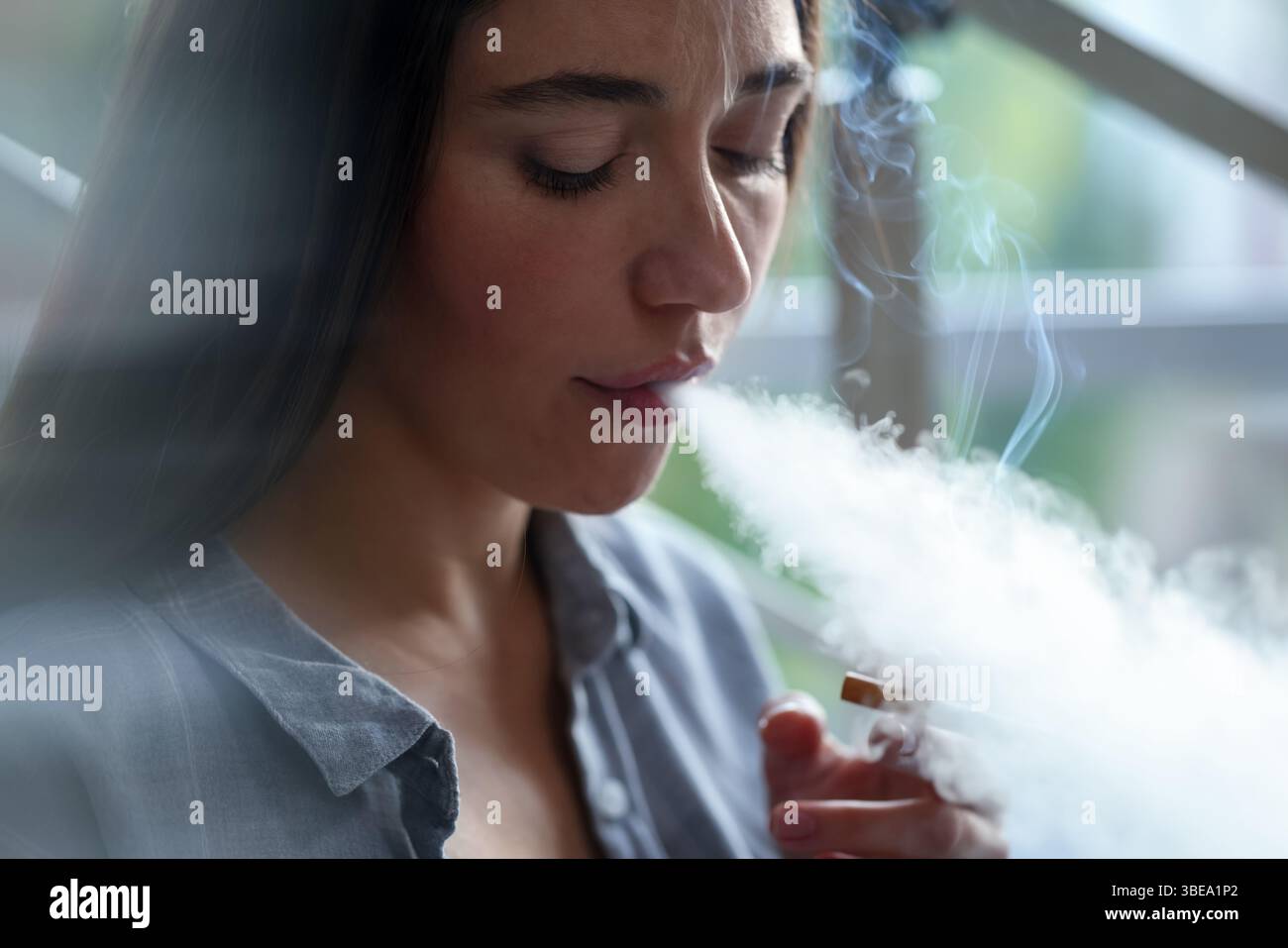 Woman smoking cigarette indoors, closeup. Bad habit Stock Photo - Alamy