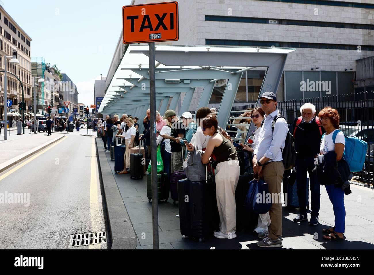 People wait in line for a taxi at Rome's Termini train station during a ...