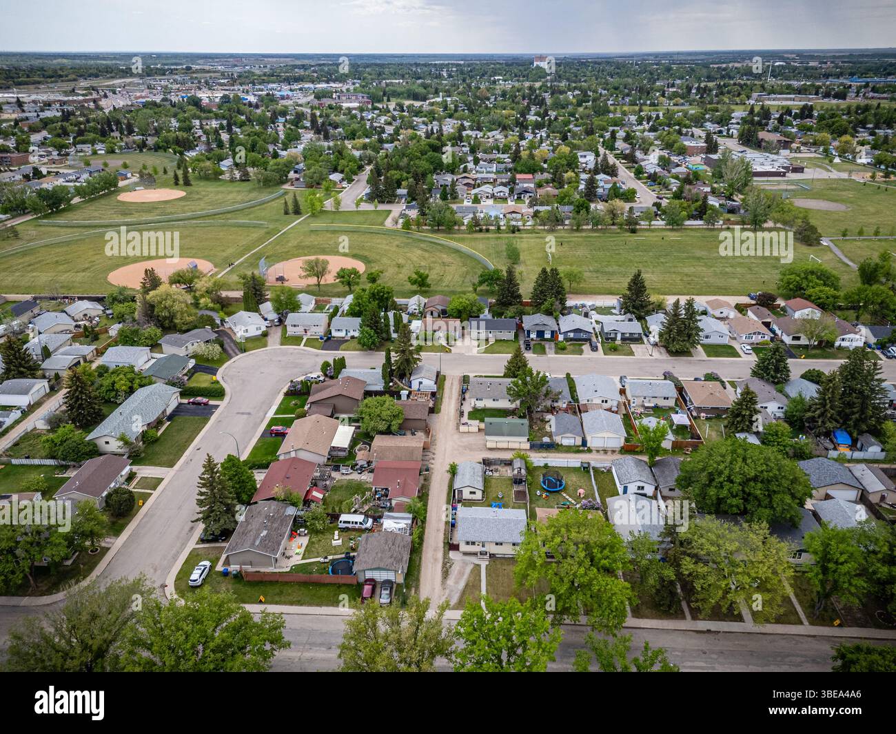 Residential neighborhood with houses and a park. The park is surrounded ...