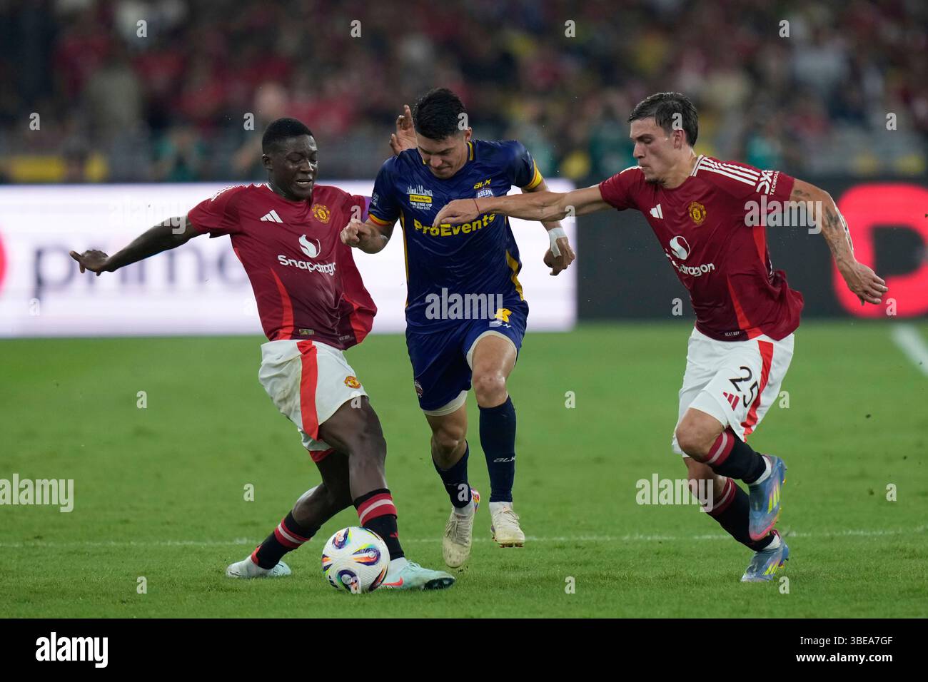 Manchester United's Kobbie Mainoo, left, fights for the ball with ASEAN ...