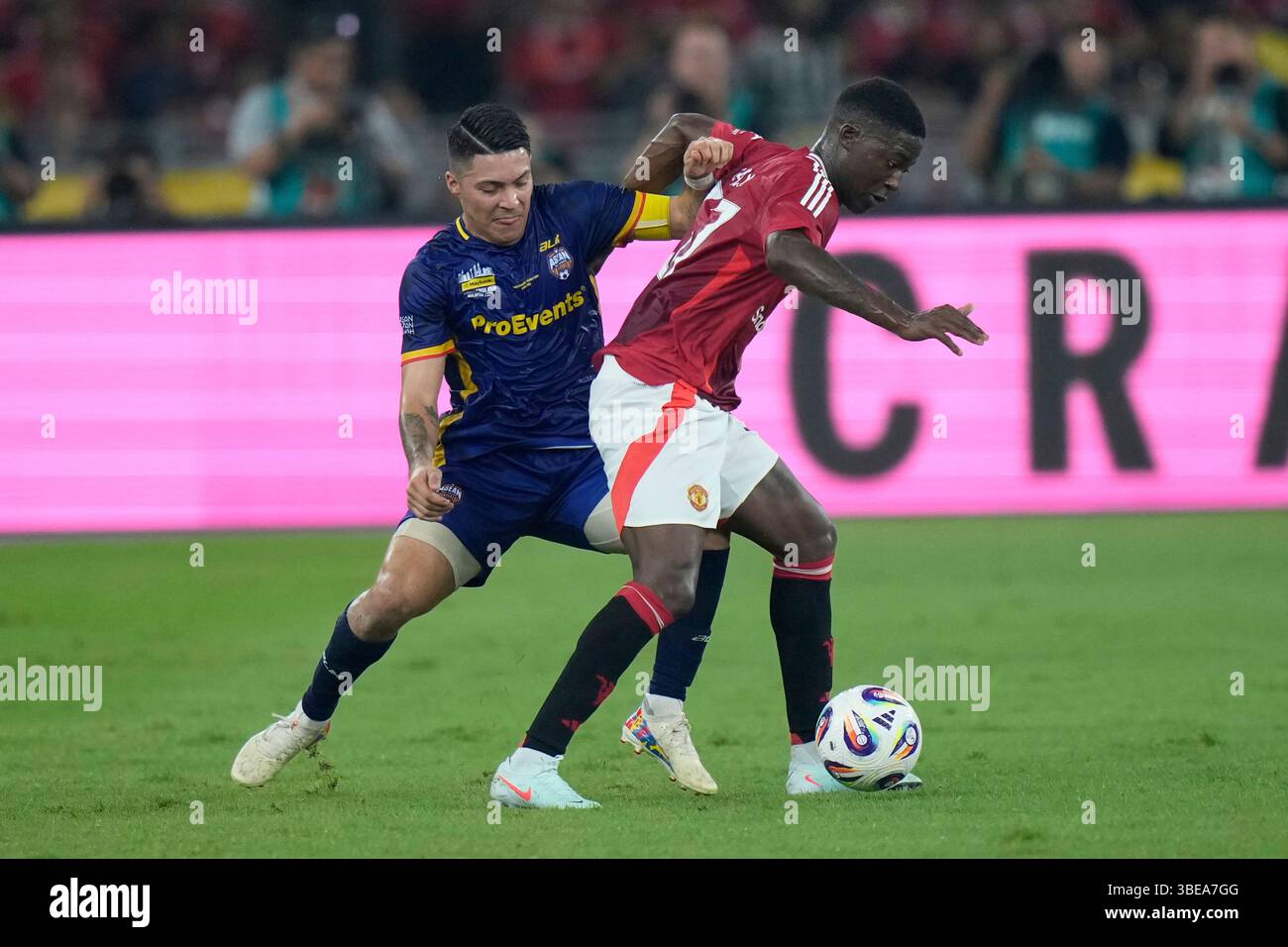 Manchester United's Kobbie Mainoo, right, fights for the ball with ...