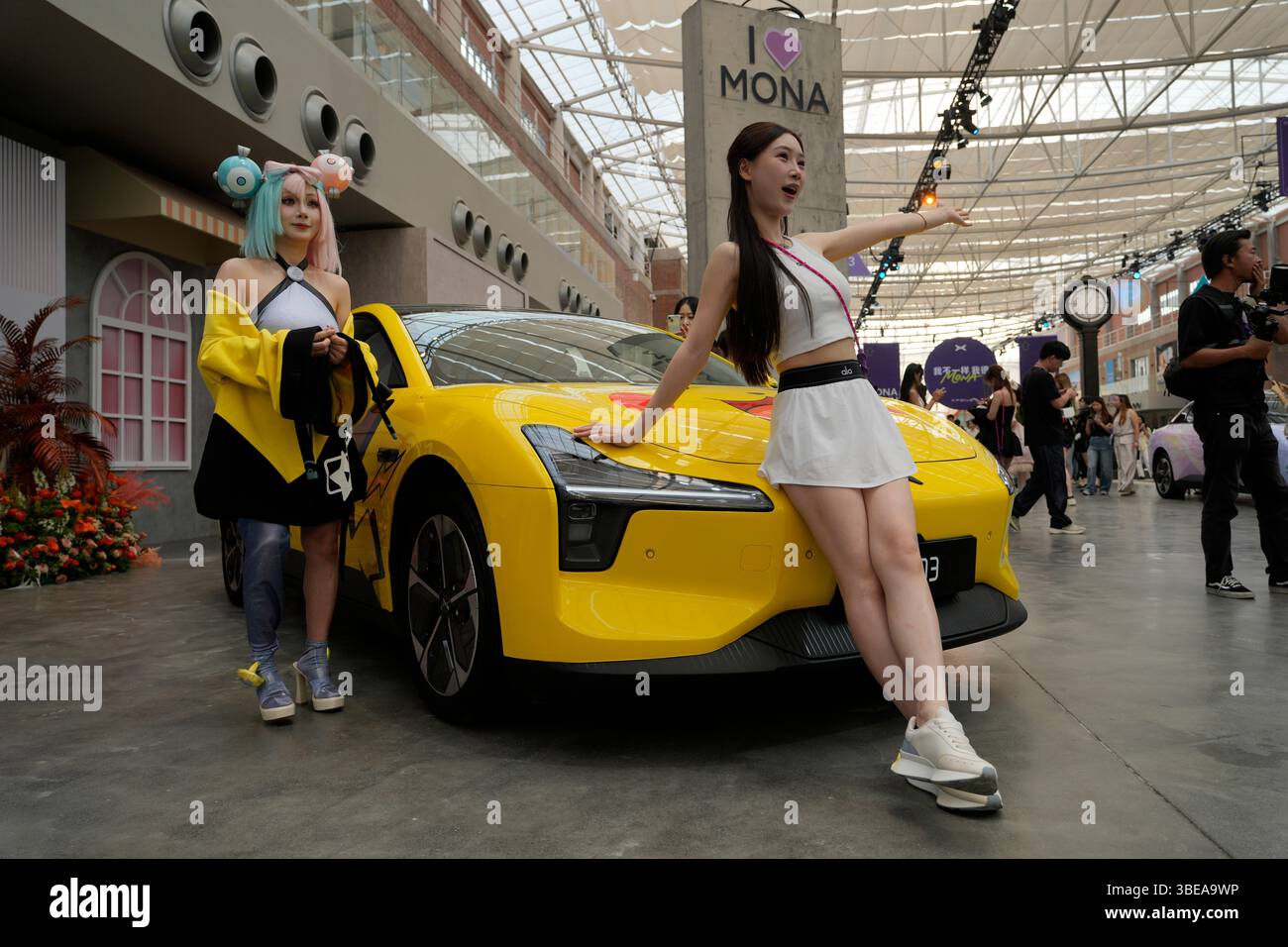 Visitors pose with the MONA M03 Max EV from Chinese automaker XPENG at ...
