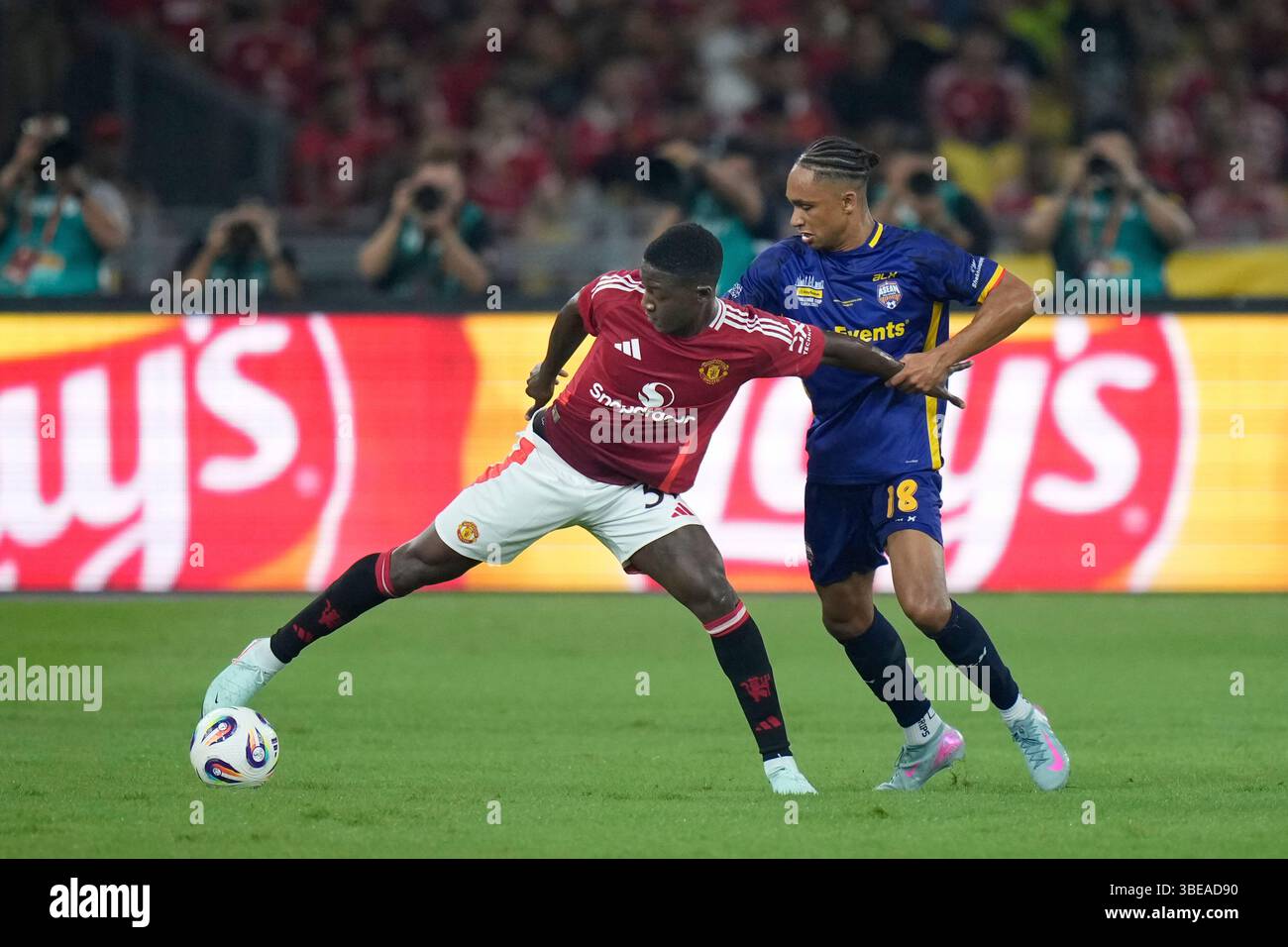Manchester United's Kobbie Mainoo, left, fights for the ball with ...