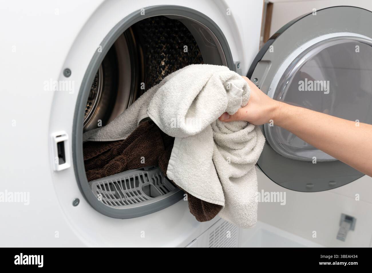 Putting on laundry, using the washing machine at home, household chores ...