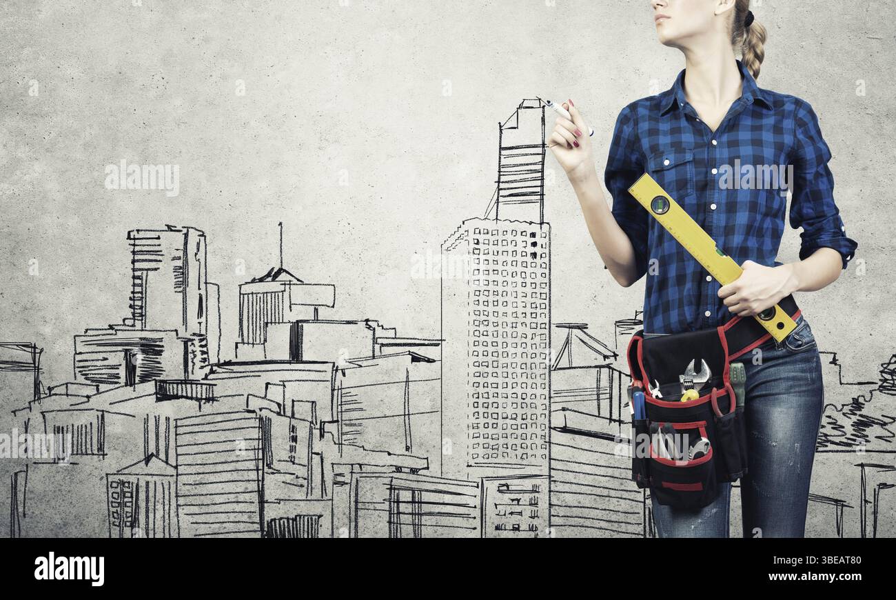 Attractive blond woman builder with ruler in hands draw construction ...