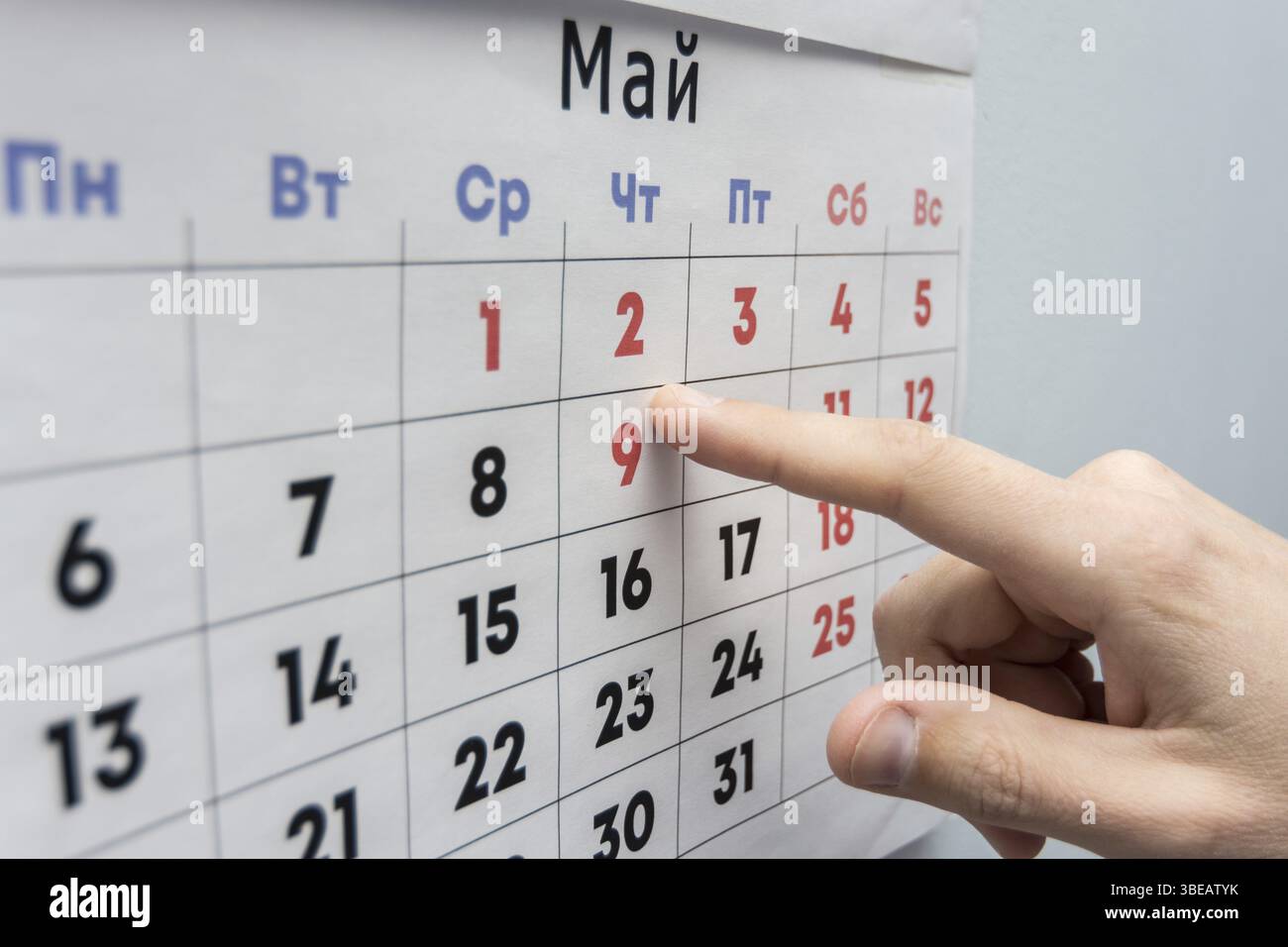 Hand points to the May 2 holiday on a wall calendar sheet Stock Photo ...