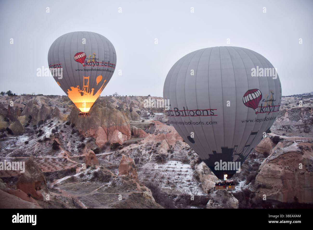 Hot air balloons rise over the unique rock formations of Cappadocia at ...