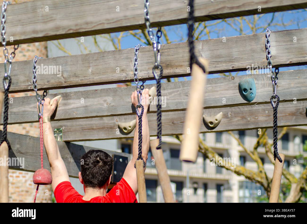 male ocr athlete tackling overhead grip rig with chains and holds Stock ...