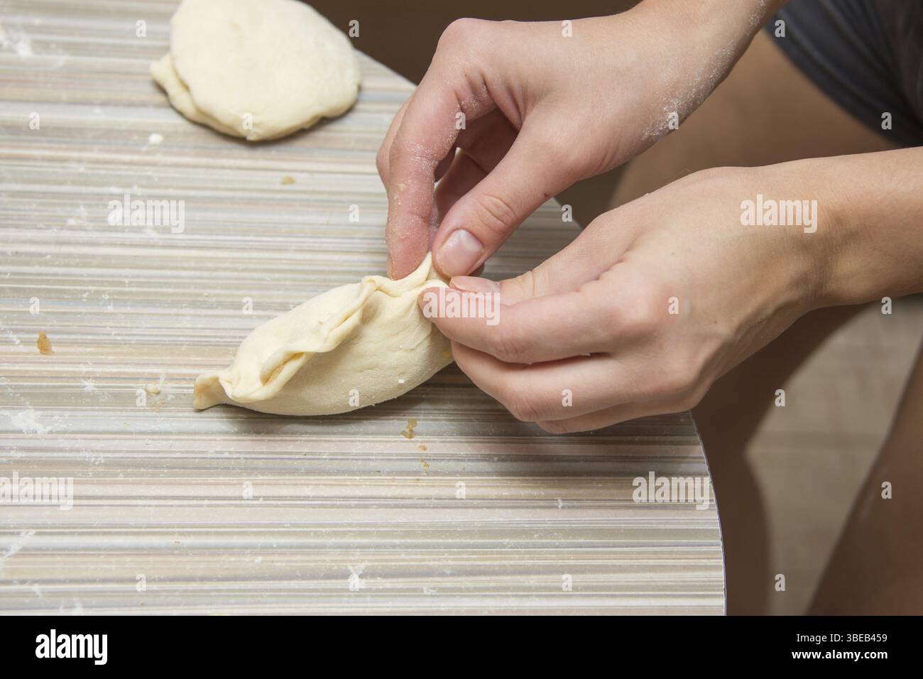 Female hands closeup molded patty with cabbage on the kitchen table ...