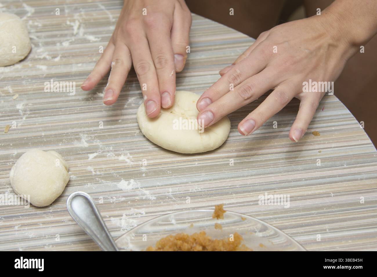 Female hands closeup molded patty with cabbage on the kitchen table ...