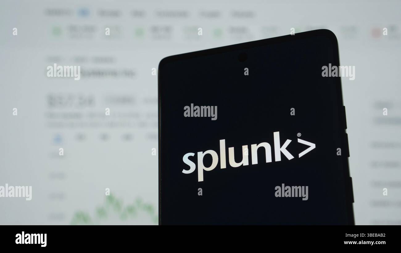 Smartphone screen with Splunk logo over a dimly lit blurred financial ...