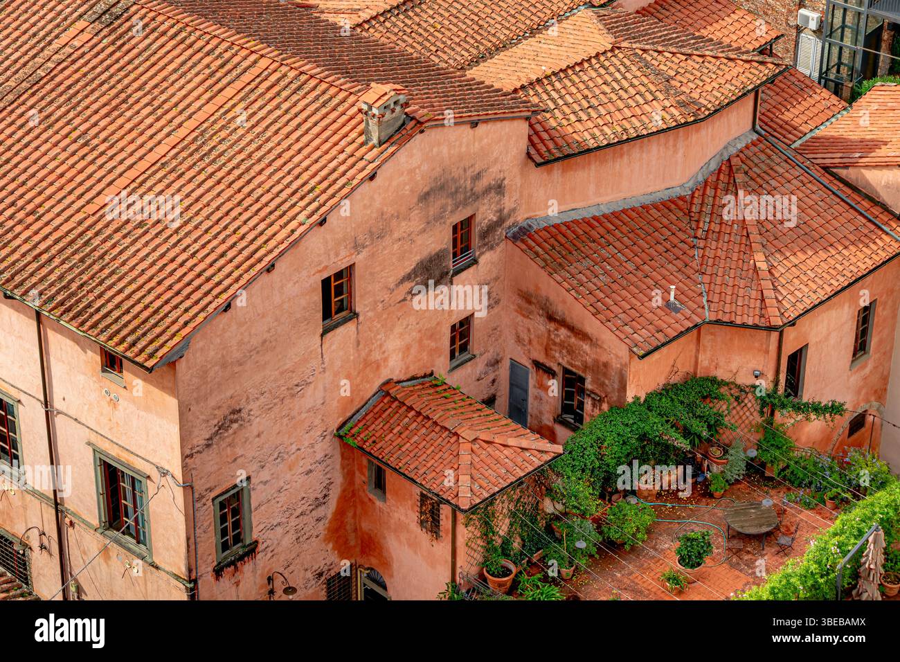 Red tiled rooftops and a small courtyard garden at the rear of a house ...