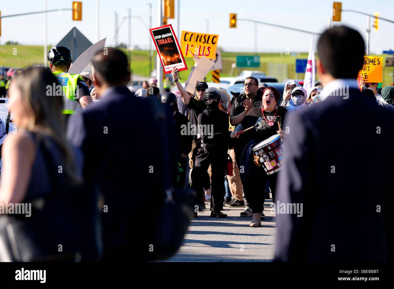 Protesters yell towards attendees arriving at the Canadian Association ...