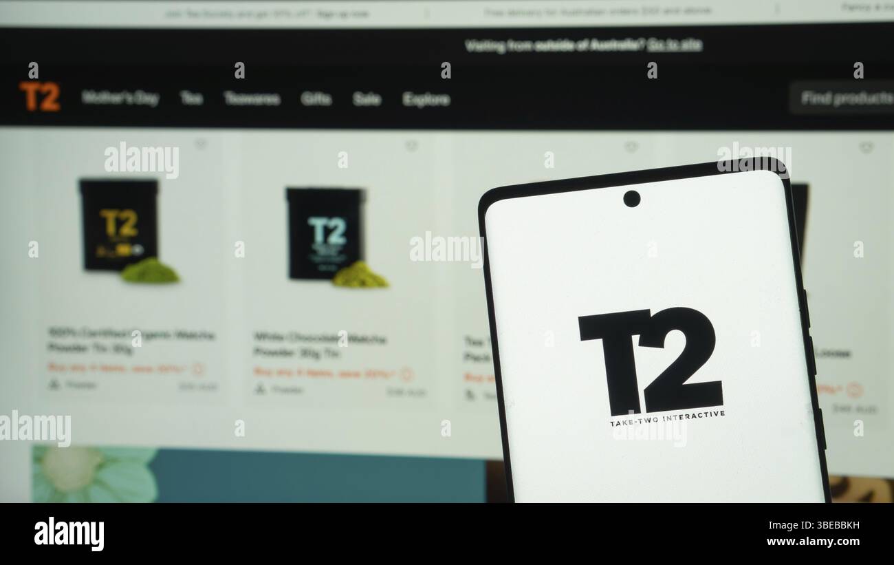 Smartphone showing T2 logo with a background of product listings Stock ...