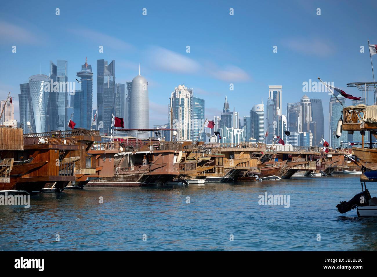 Traditional boats at the Dhow Harbor with doha skyline, Qatar Stock ...