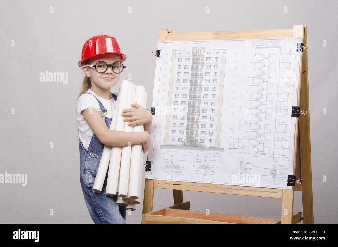Girl Builder, architect, holding a bunch of drawings, standing at the ...