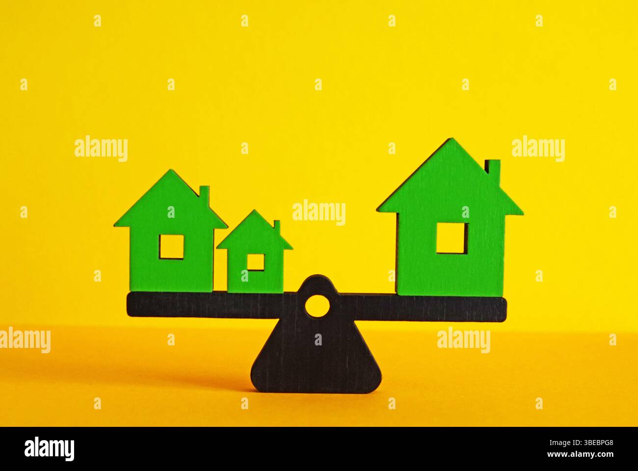 Scales with two small houses and one large. Real estate comparison ...
