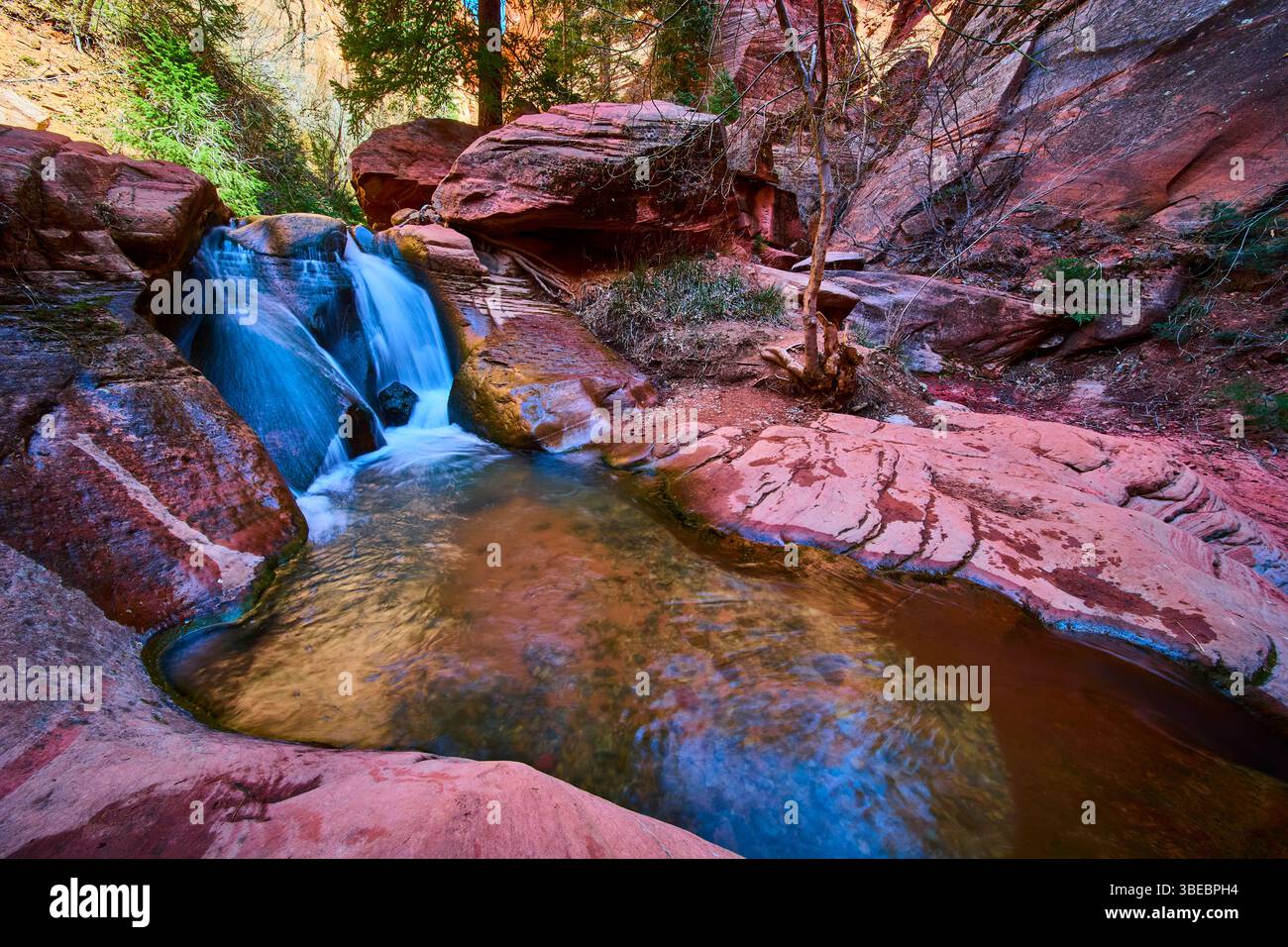Waterfall Motion Over Red Sandstone and Reflective Pool Eye Level View ...