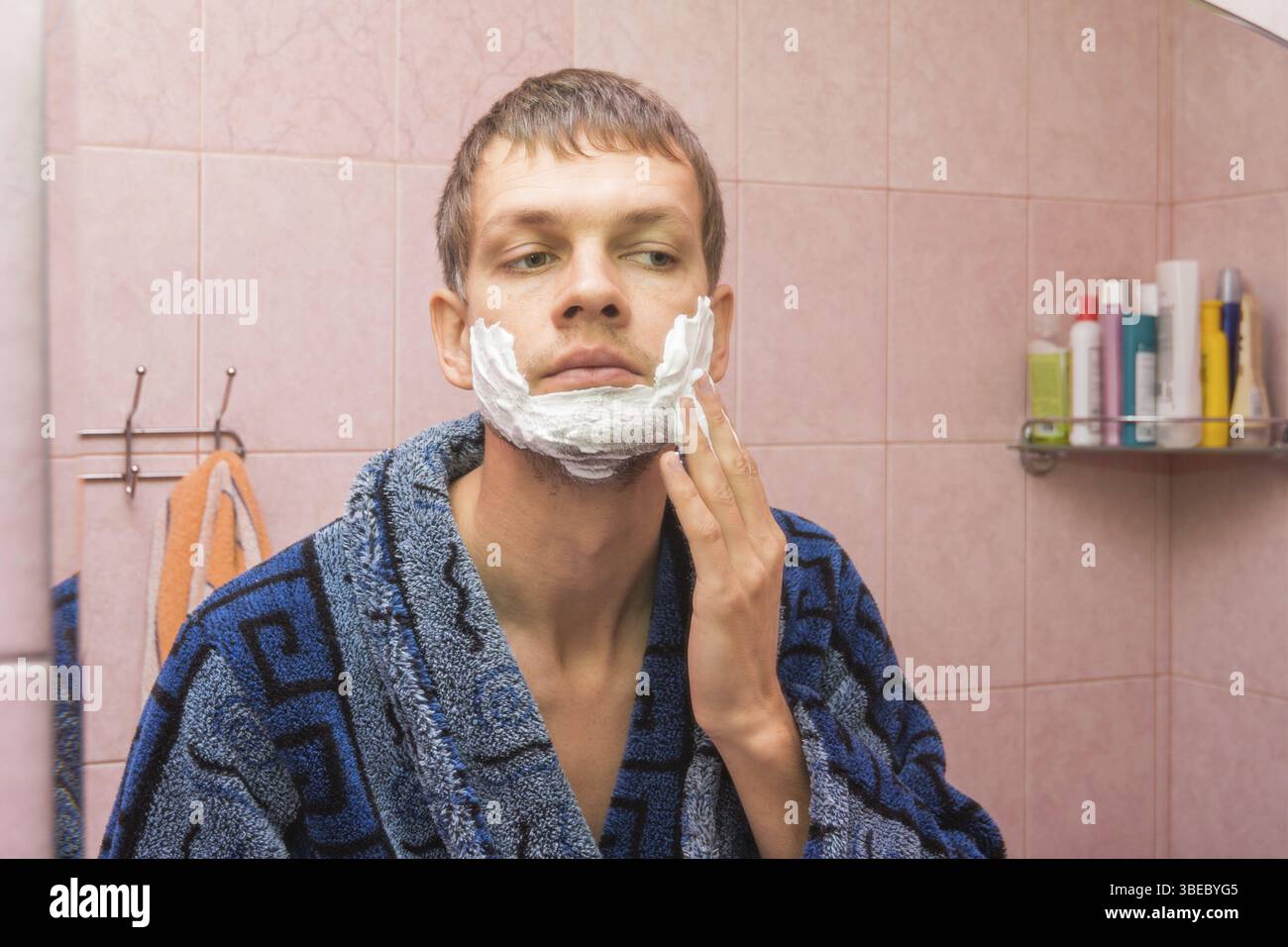The young man gets shaving foam on his cheeks Stock Photo - Alamy