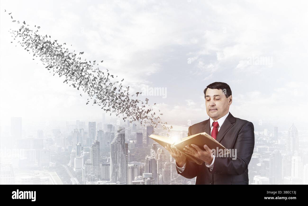 Senior businessman holding open old book. Manager in suit standing on ...