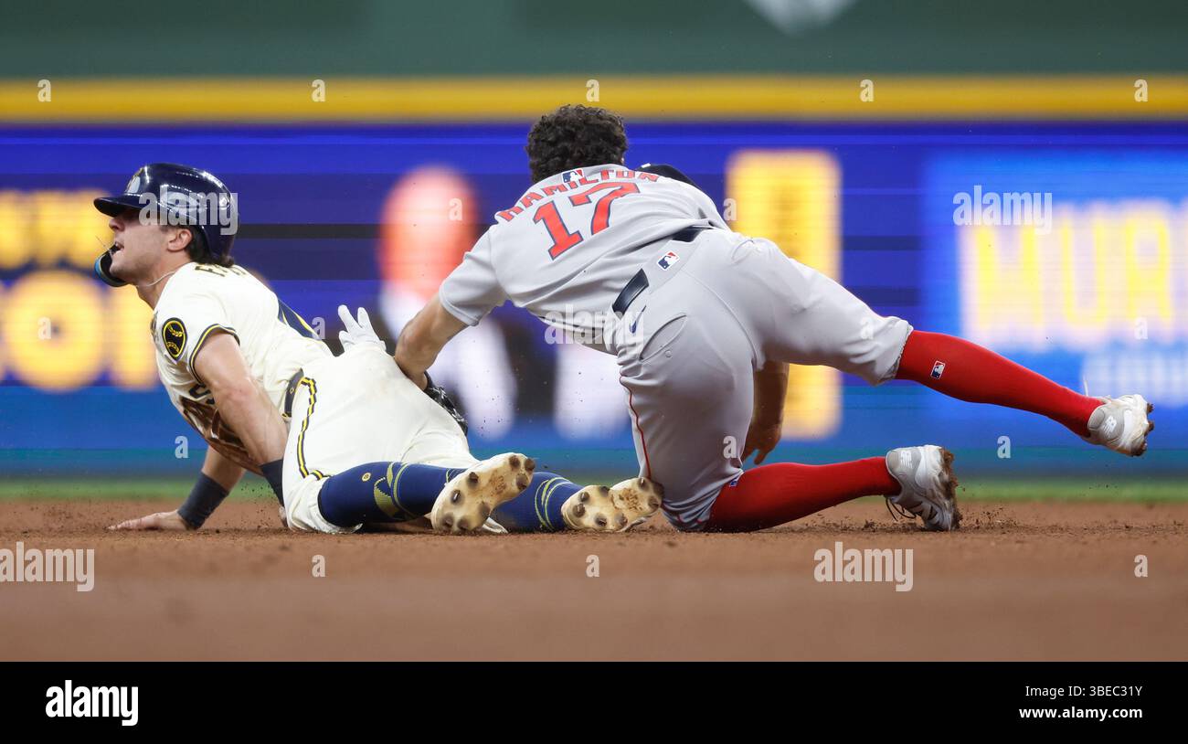 Milwaukee Brewers' Sal Frelick, left, slides in safely to second base ...