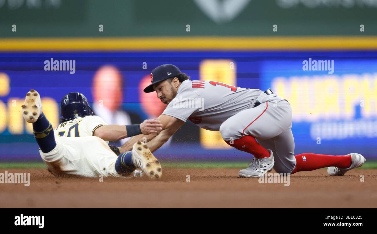 Milwaukee Brewers' Sal Frelick, left, slides in safely to second base ...
