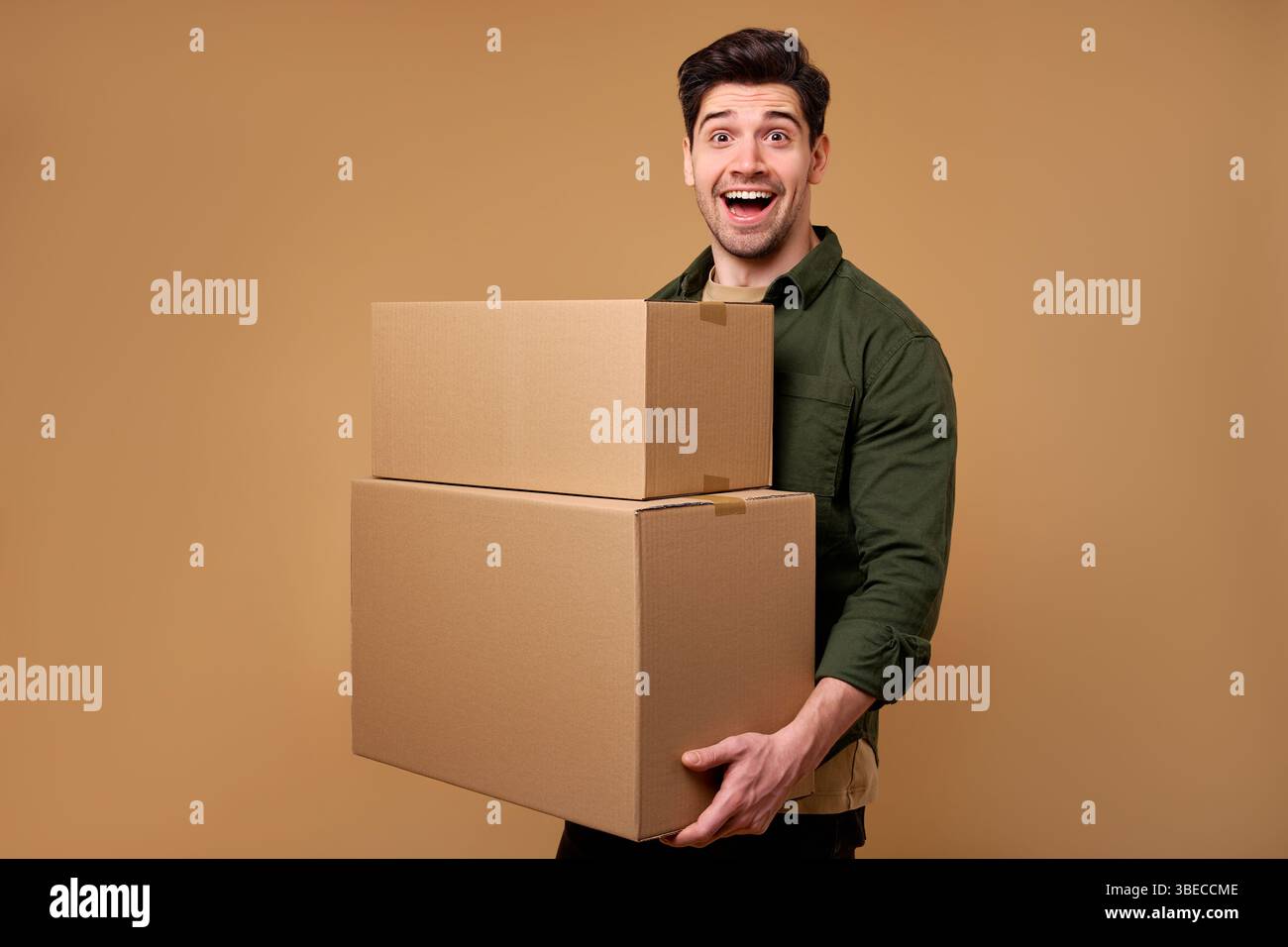 A cheerful man confidently standing, carrying two cardboard boxes. The ...