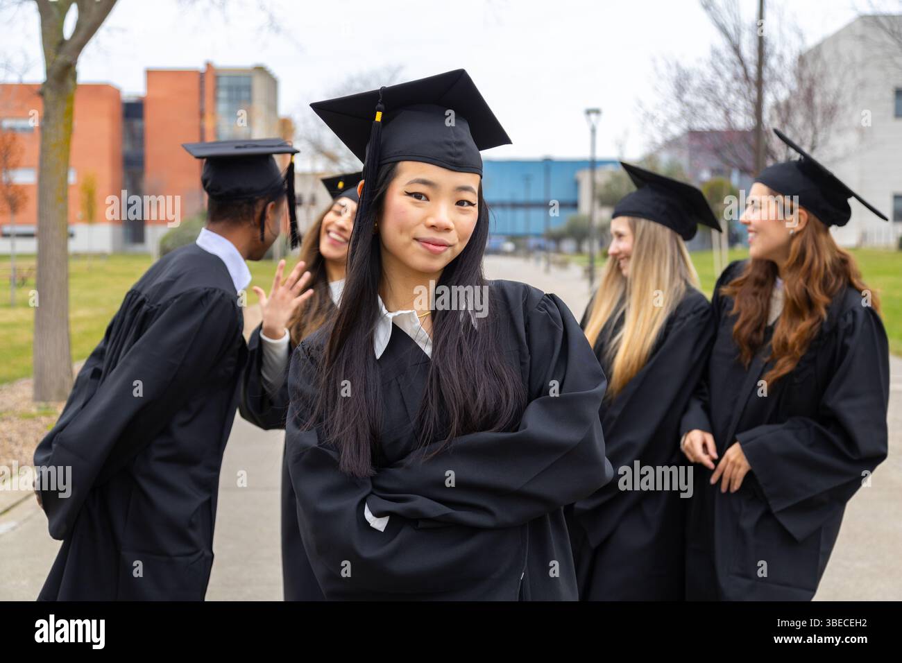 Proud graduates wearing their academic gowns and caps, celebrating ...