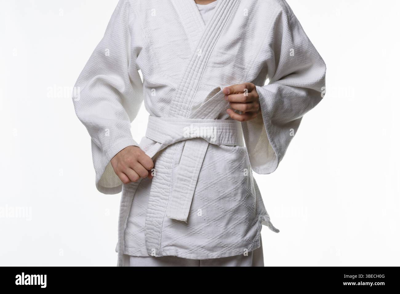 Stages of correct tying of the belt by a teenager on a sports kimono ...