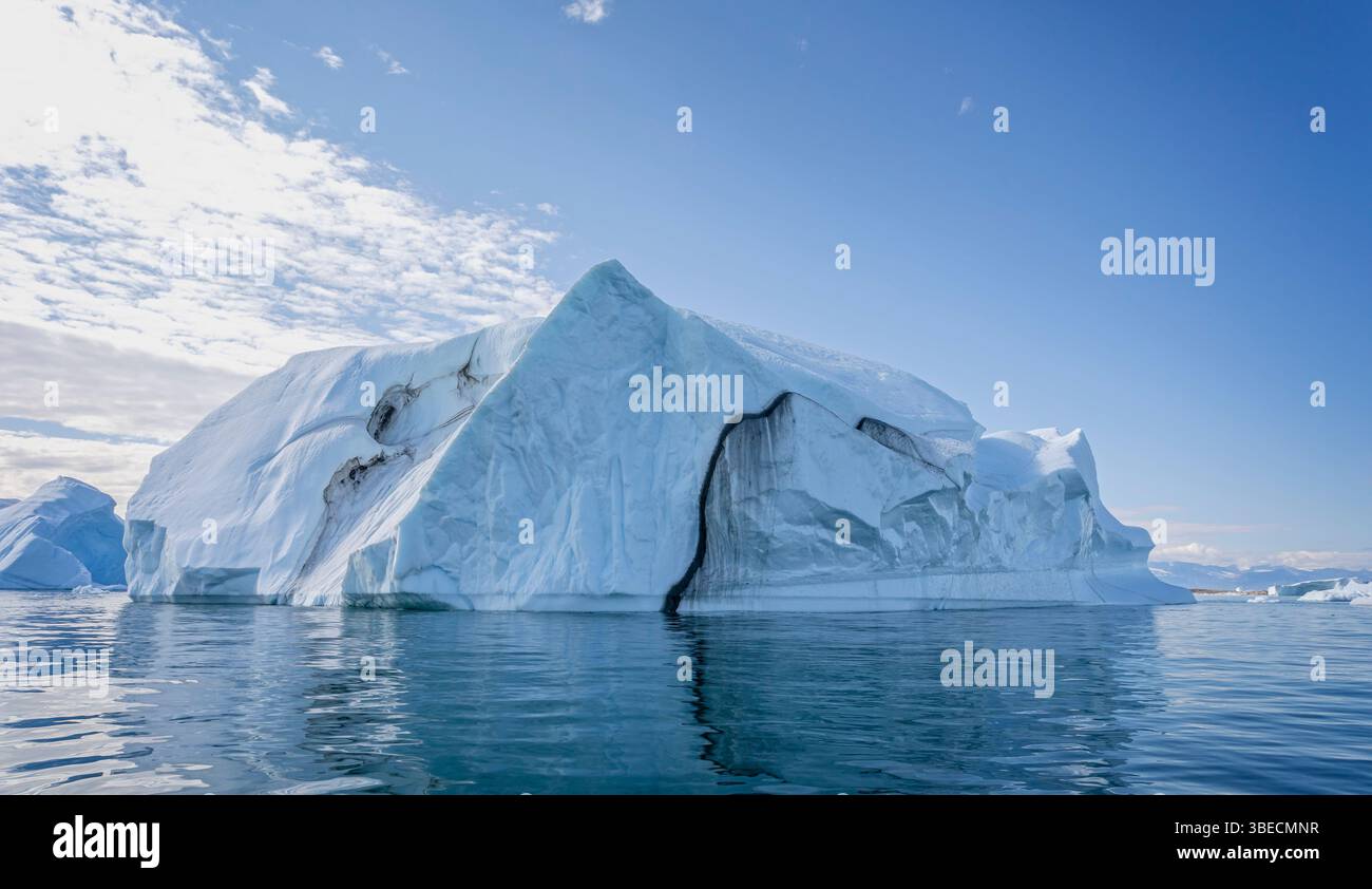 Large iceberg with deep crevasse and dramatic sky in Disko Bay in ...