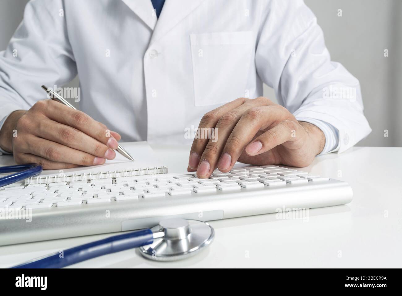Doctor typing on wireless computer keyboard in office. Physician in ...