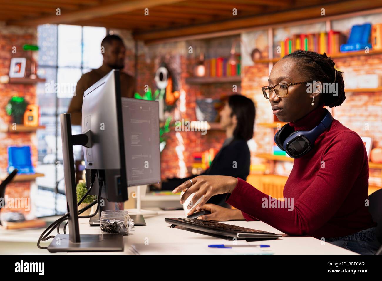 Programmer in startup office using large language model to get help with coding project. African ...