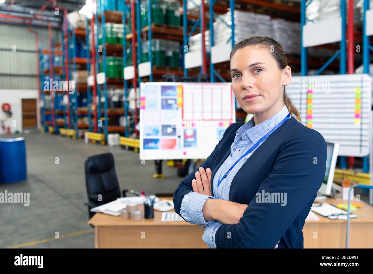 White female warehouse supervisor standing in office by desk ...