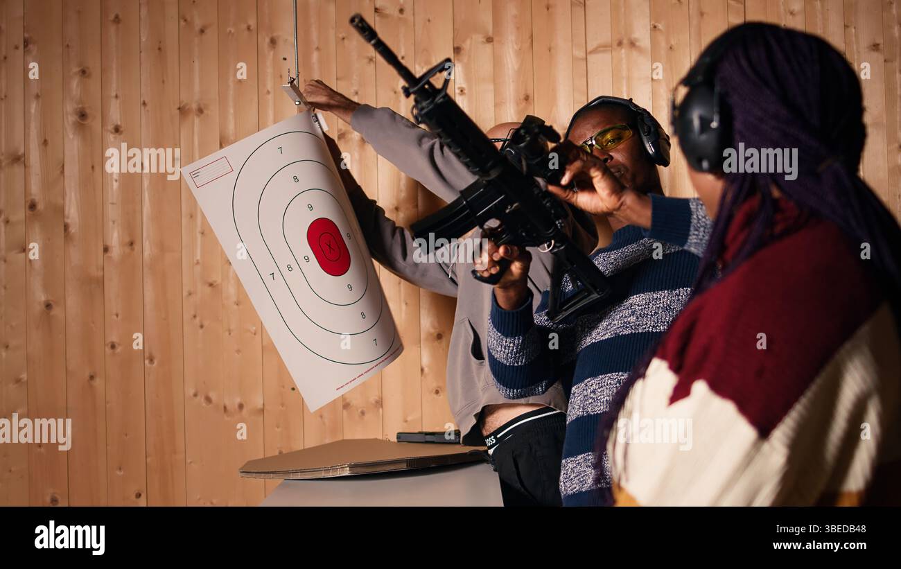 Group of friends in firing range shooting targets, wearing earmuffs to ...