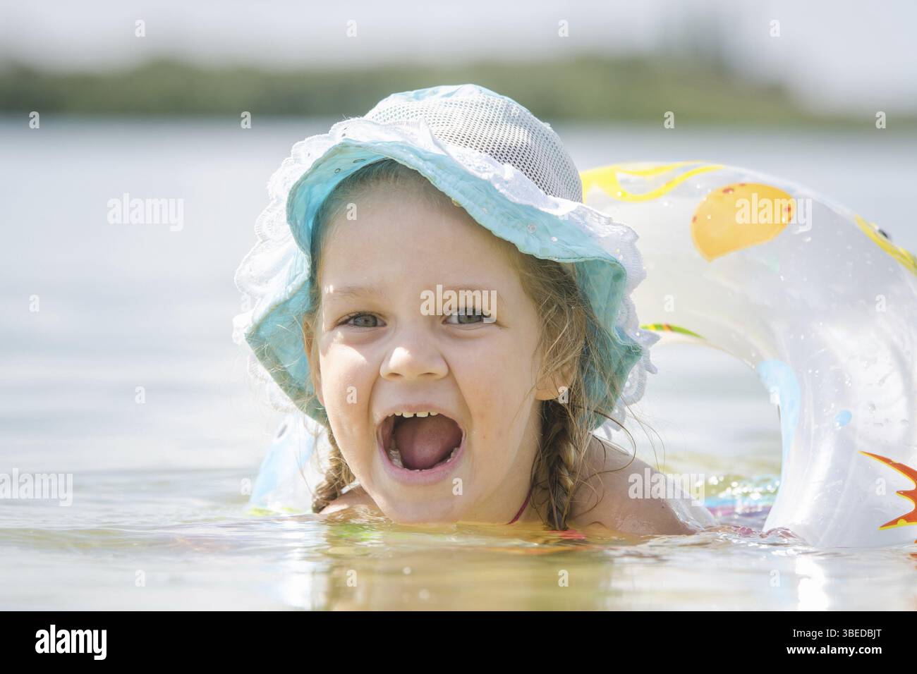 Four-year girl with an open mouth with happiness bathed in the river ...
