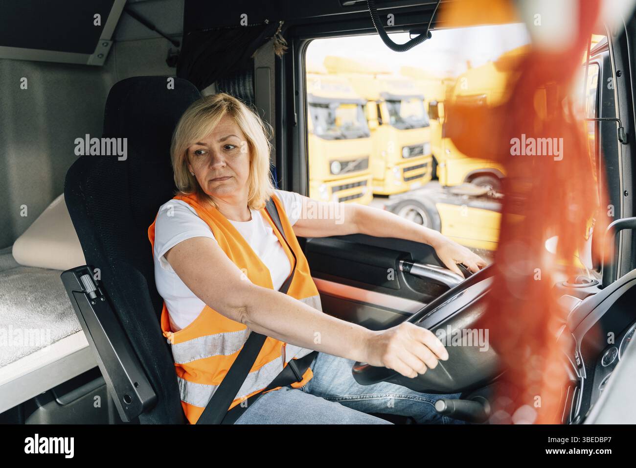 Mature woman truck driver steering wheel inside lorry cabin. Happy ...