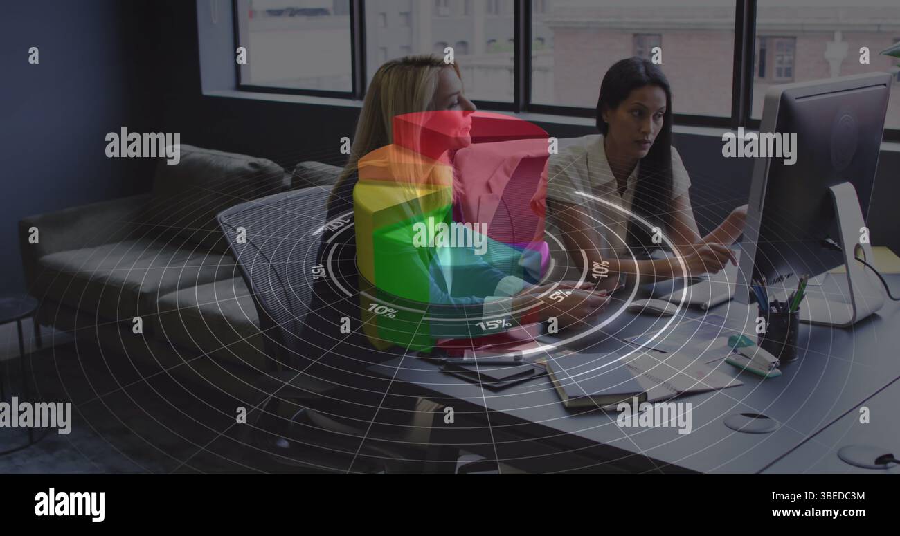 Discussing project two colleagues sitting at office desk, with monitor ...