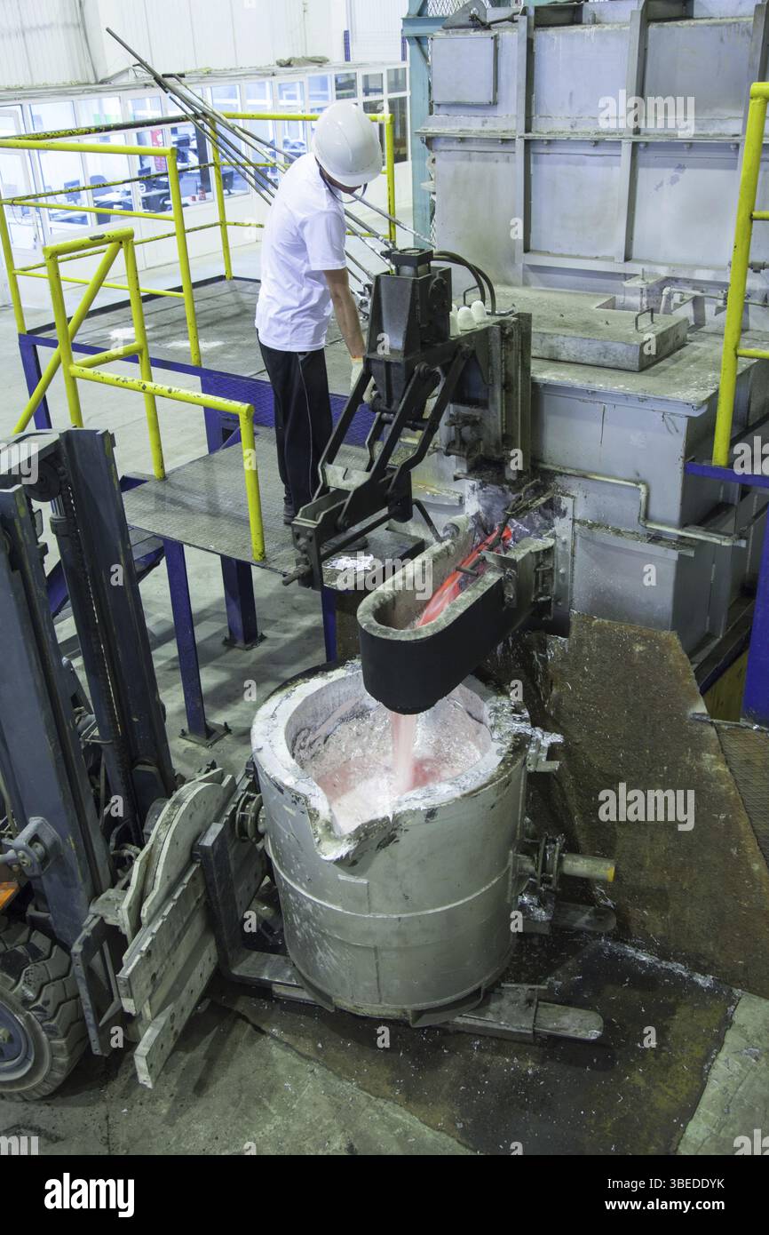 Factory worker for the smelting of aluminum metal in the bucket ...