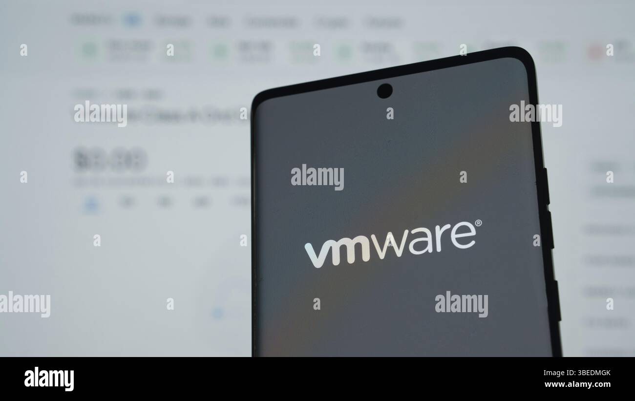 VMware logo on a smartphone screen against a blurred financial chart ...
