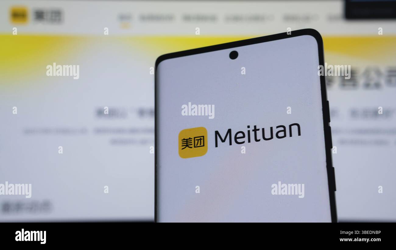 Smartphone displaying Meituan logo with yellow background on a digital ...