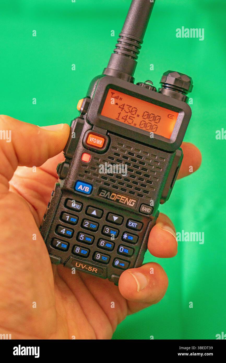 small amateur radio walkie-talkie baofeng UV-5R under green background ...