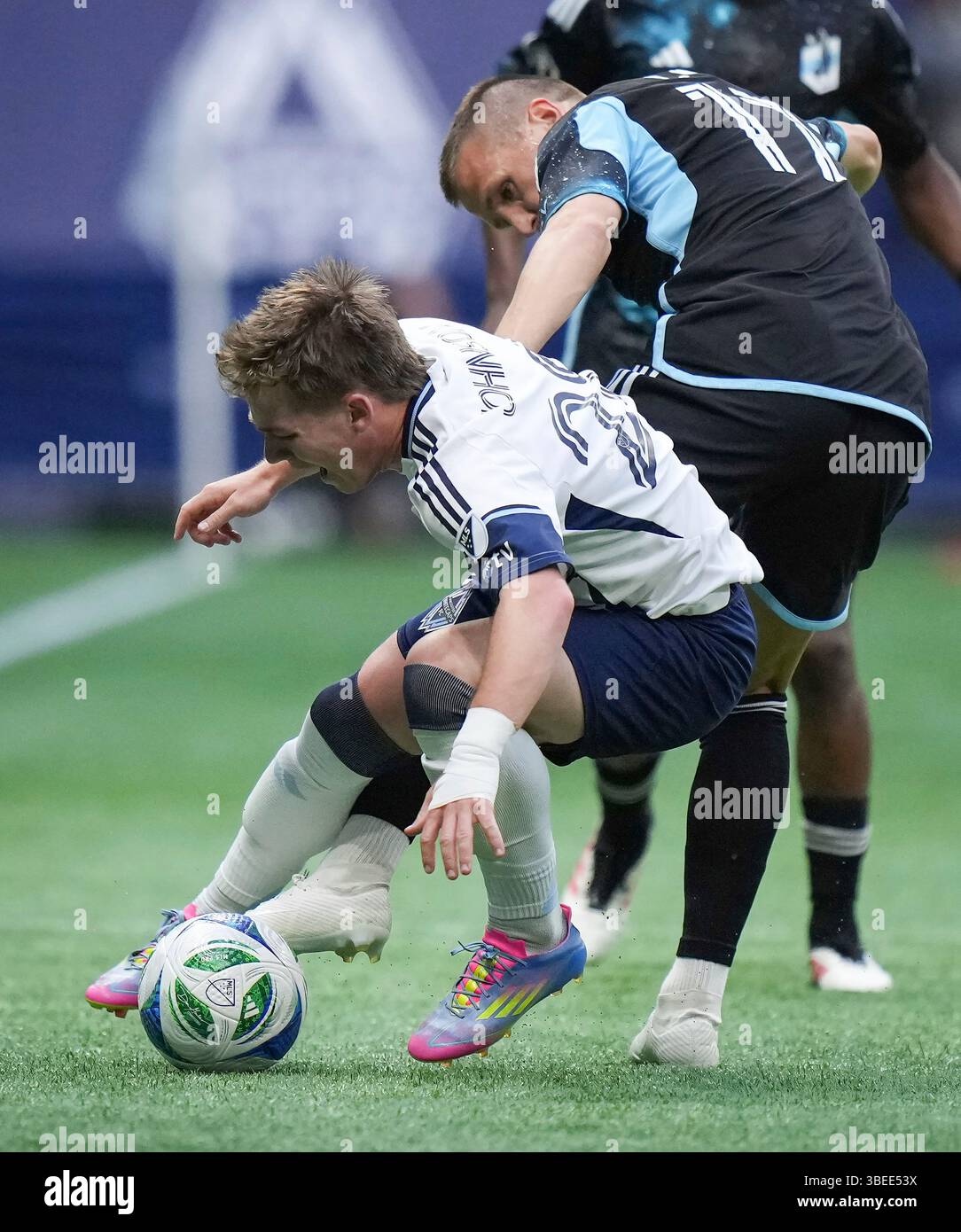 Vancouver Whitecaps' Tate Johnson, front, is upended by Minnesota ...