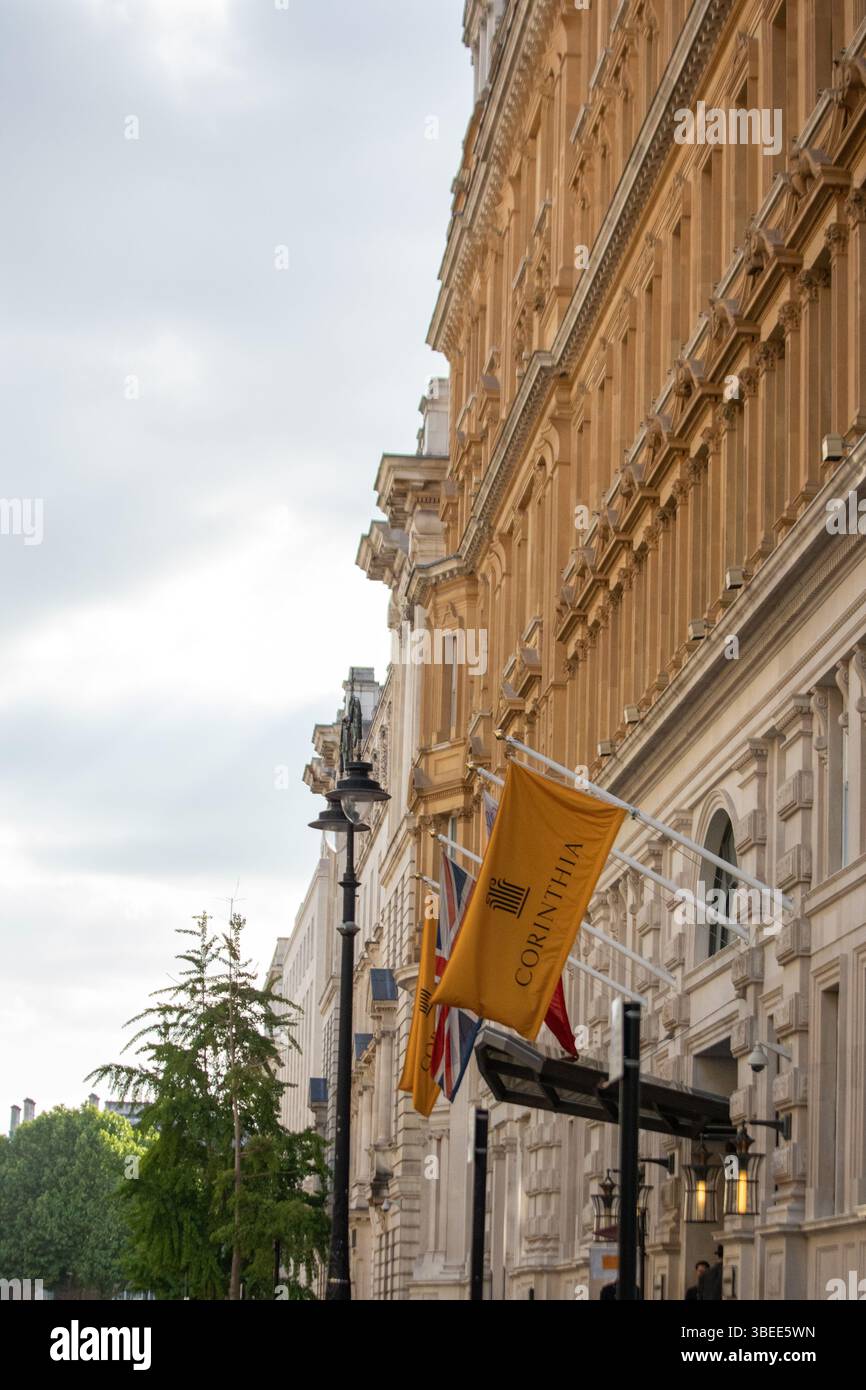 A detailed view of a classical building facade with flags in central ...