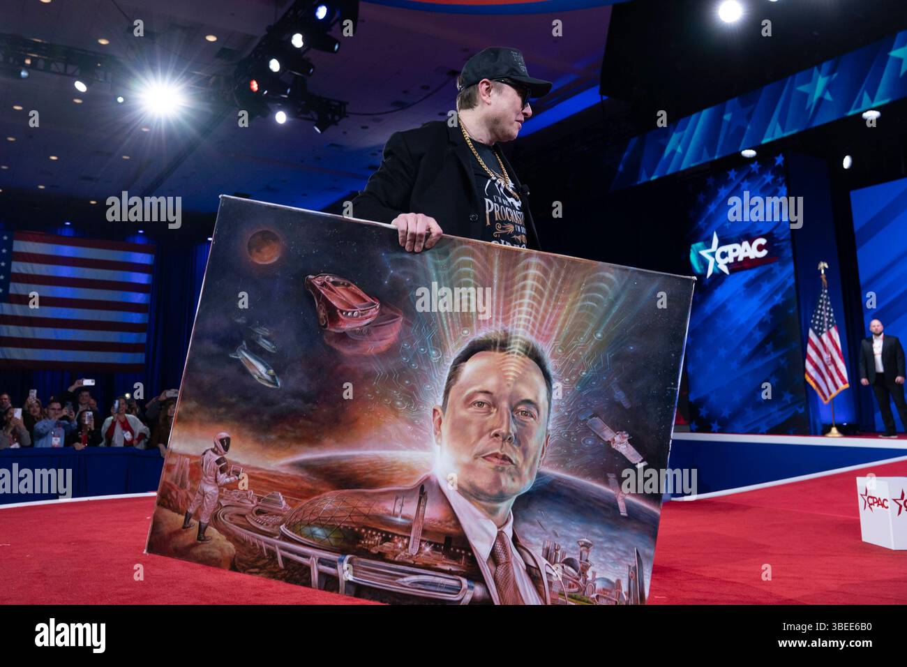 FILE - Elon Musk holds a painting after speaking at the Conservative ...