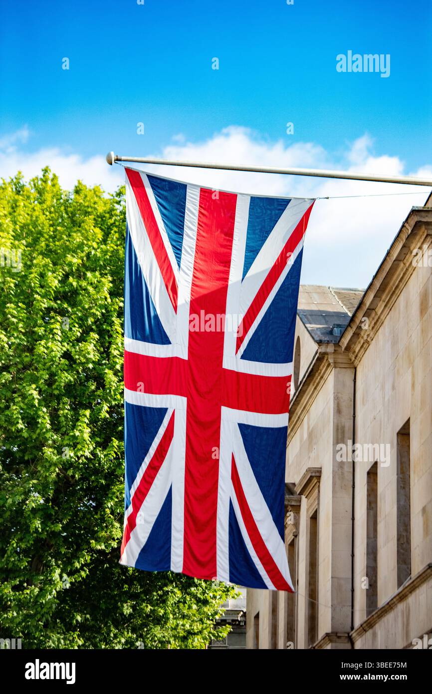 A Union Jack flag hangs from a building in London on a bright day Stock ...