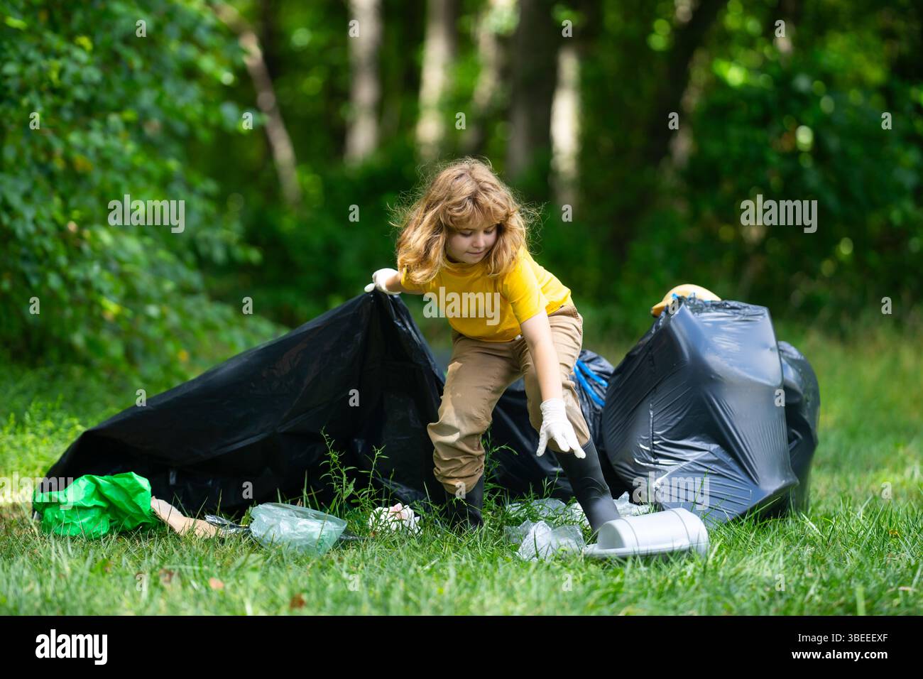 Child picking plastic trash for cleaning the nature. kid Clean up ...