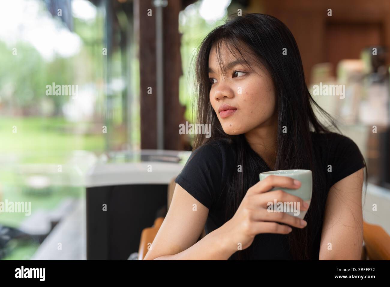 Young teenage woman sitting hi-res stock photography and images - Alamy