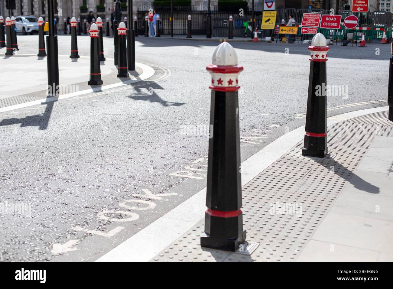 Black bollards line a street in Central London with clear signage and ...