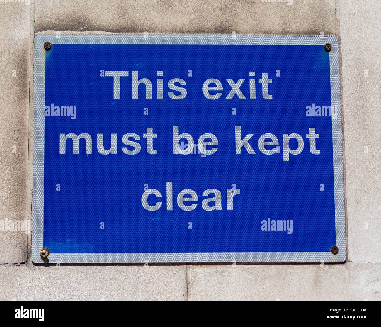 Close-up of a blue sign stating This exit must be kept clear Stock ...